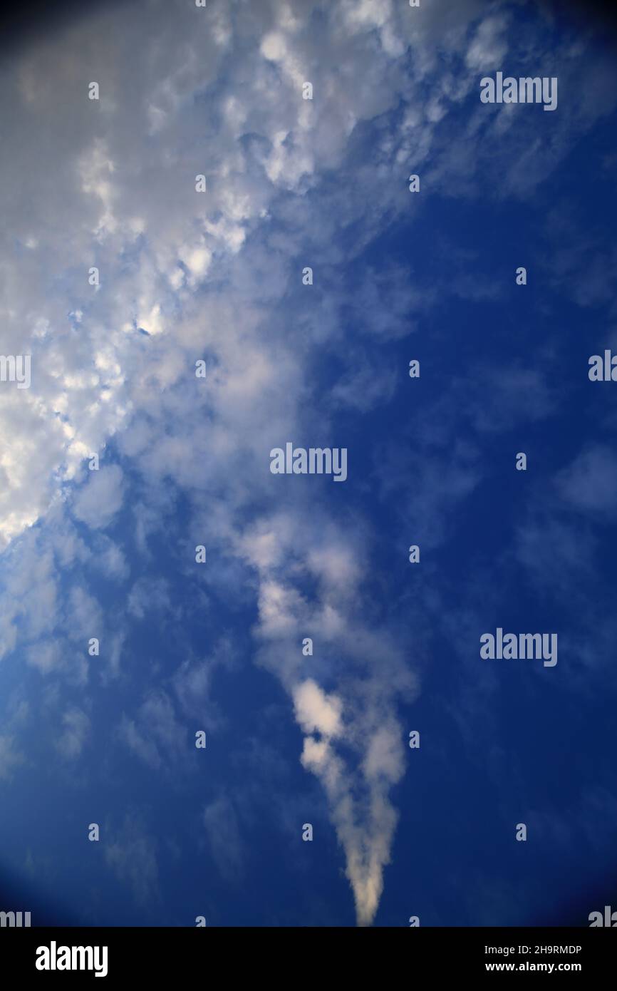 Smoke pillar in a sky with fluffy clouds Stock Photo - Alamy