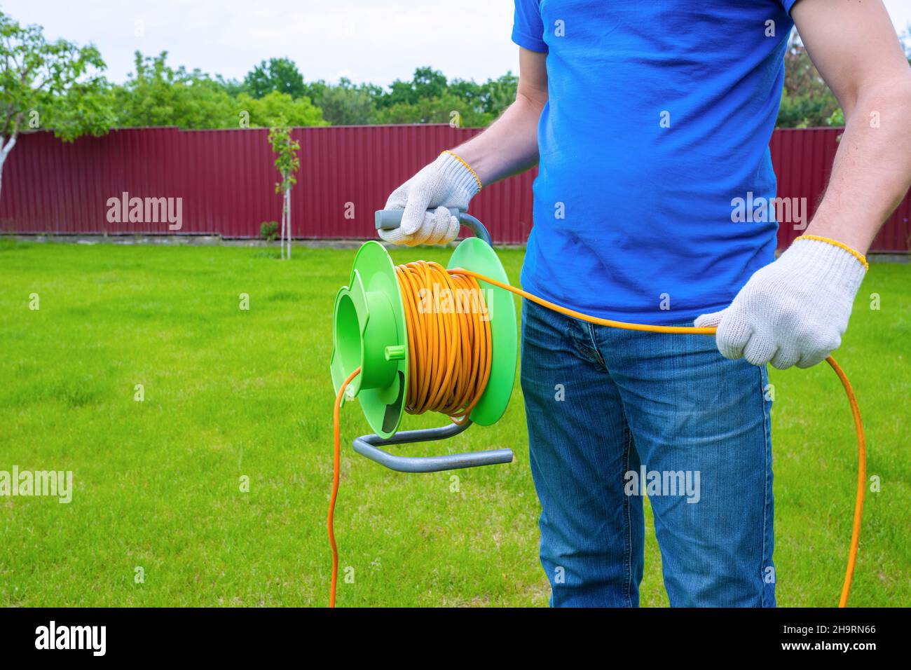 Electrician with extension coil in the backyard. Close-up Stock Photo ...