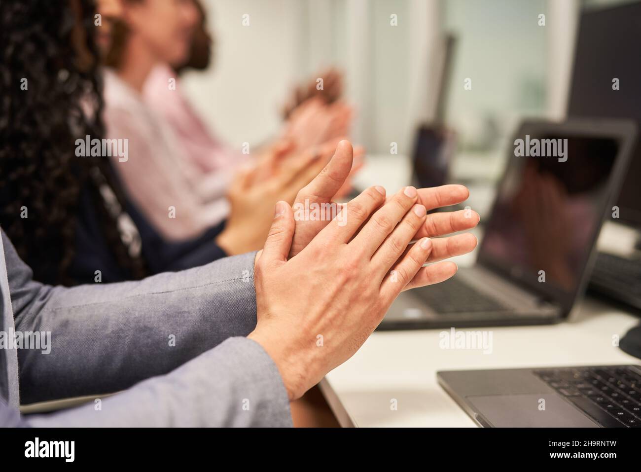 Business people applaud after a presentation at a computer workshop ...