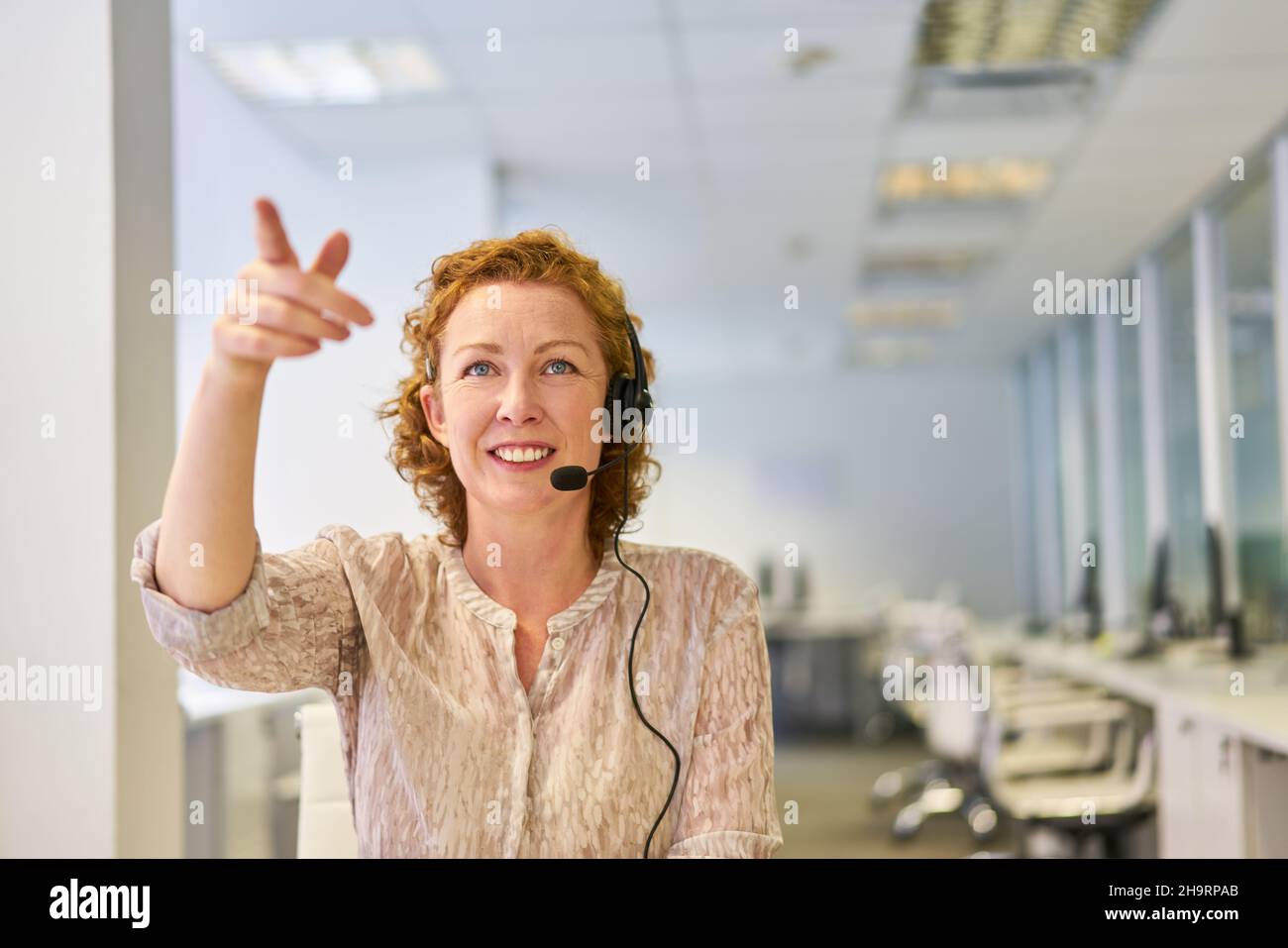 Customer advisor with a headset in the service hotline or in a video ...