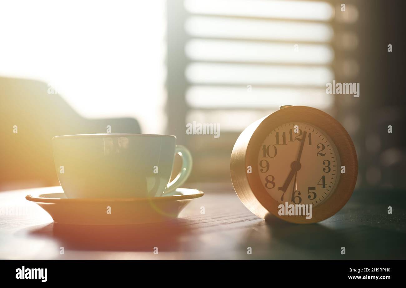 Morning at seven o'clock. Clock and a cup of tea Stock Photo - Alamy