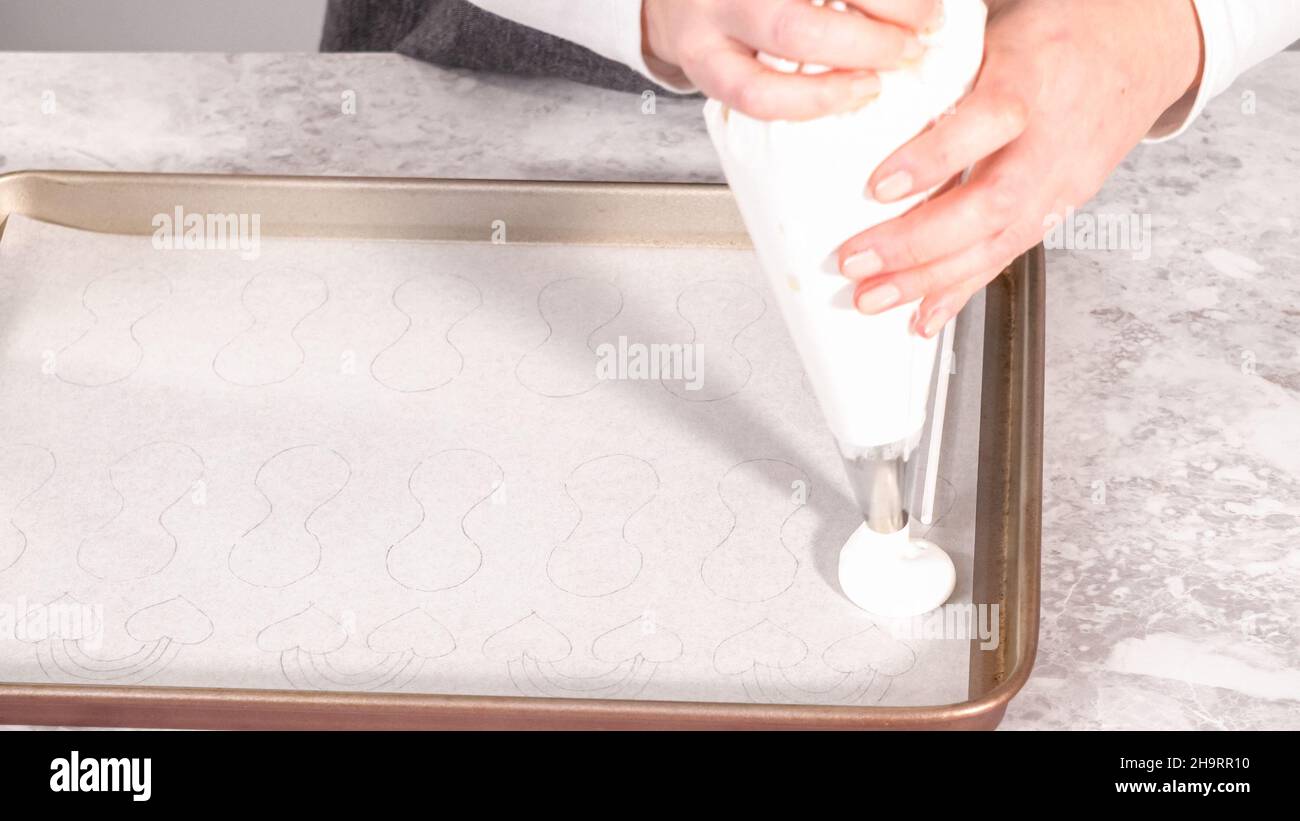 Step by step. Piping meringue mix into unicorn-shaped pops on a baking ...