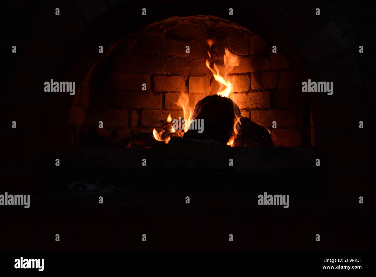Cozy scene with a flame glowing in the fireplace at night Stock Photo ...