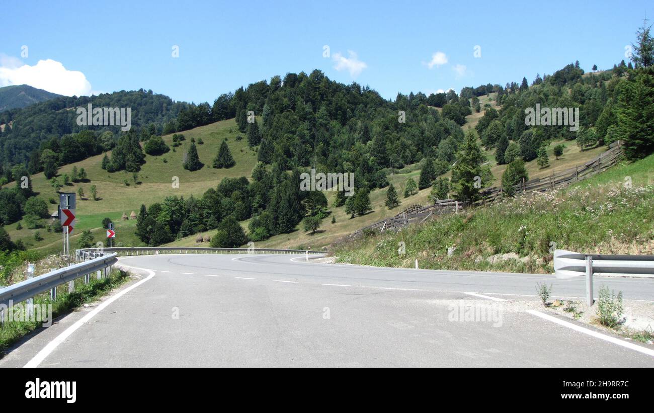 View of a road with beautiful hills covered by fir trees in a ...