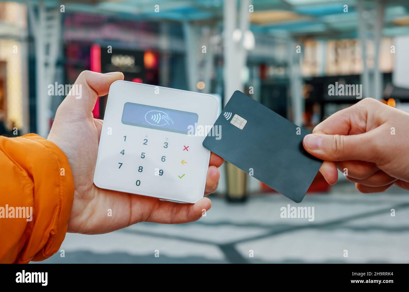 Crop unrecognizable female customer with plastic card making NFC ...