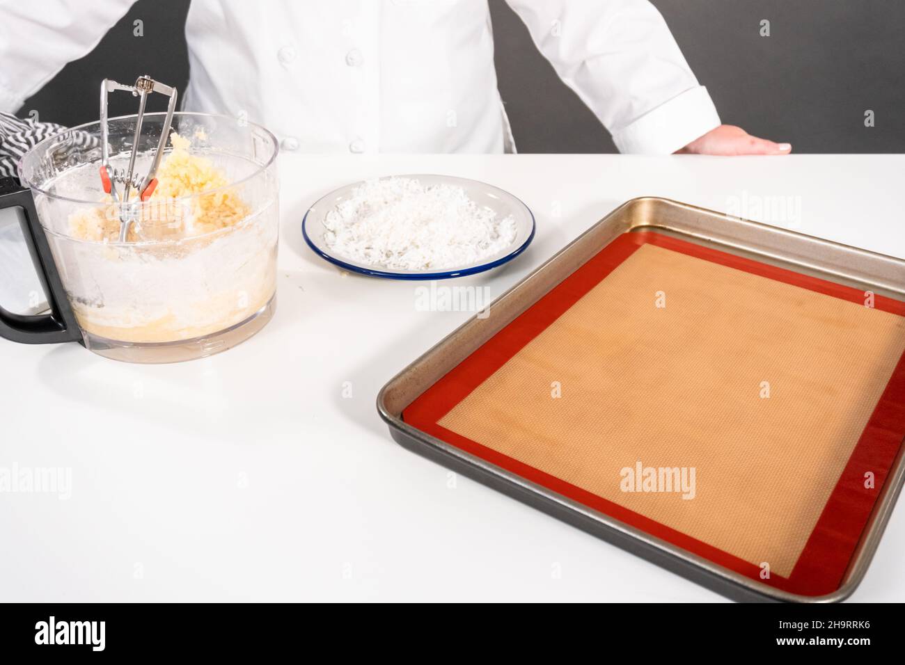 Scooping dough with dough scoop and after rolling in coconut flakes to ...