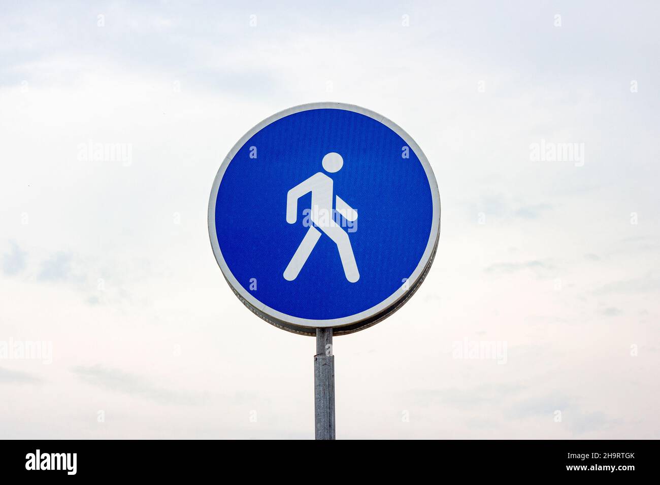 Blue and white round caution road sign for walkway zone and pedestrians ...