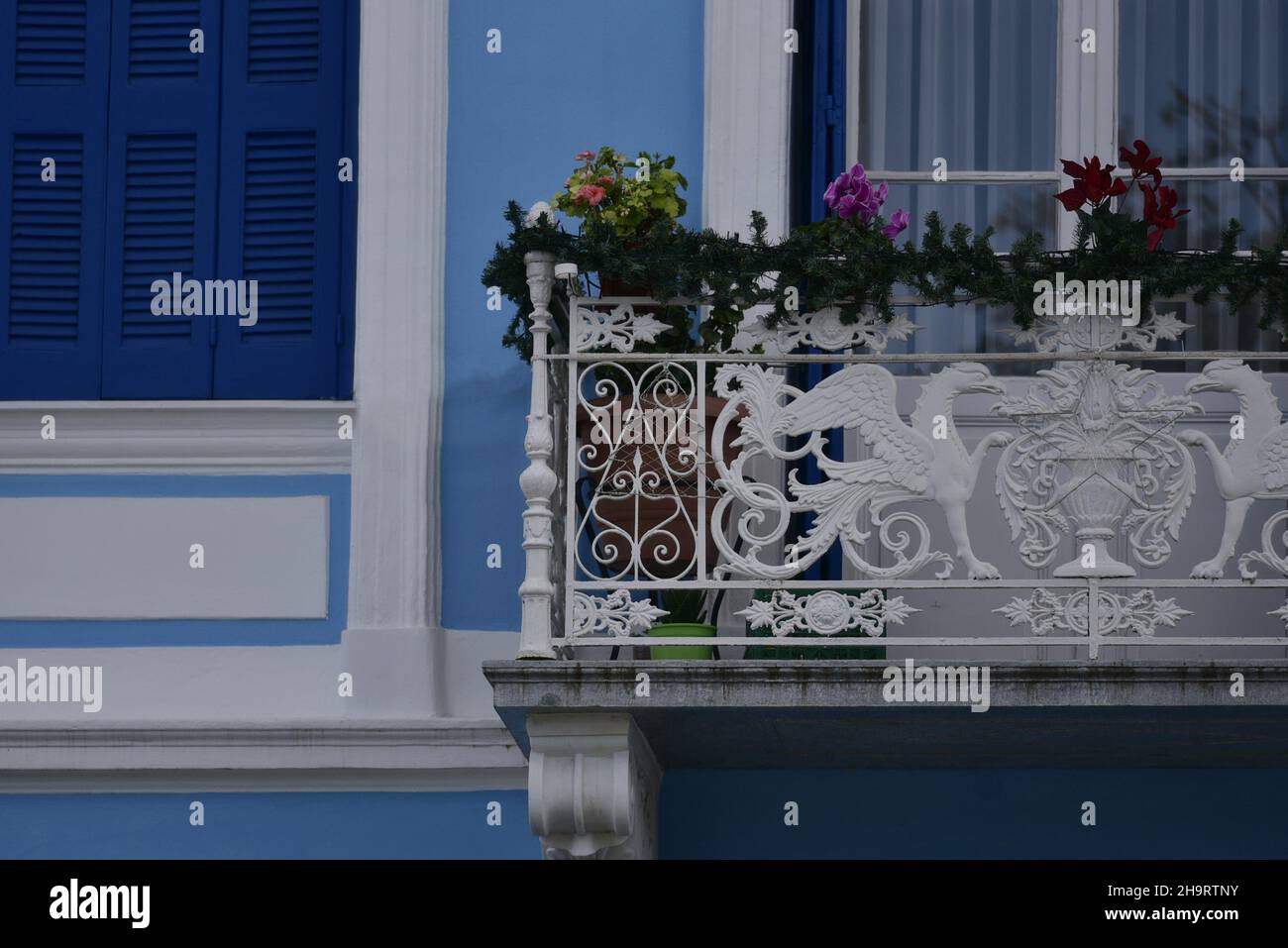 Old Neoclassical house facade with a two-tone blue wall, white trim and ...