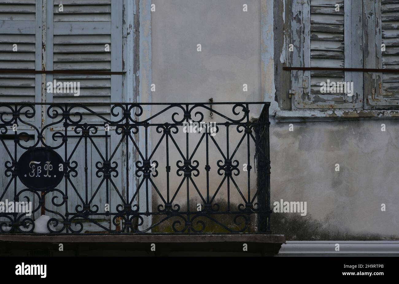 Neoclassical house facade with a weathered wall, light blue wooden ...