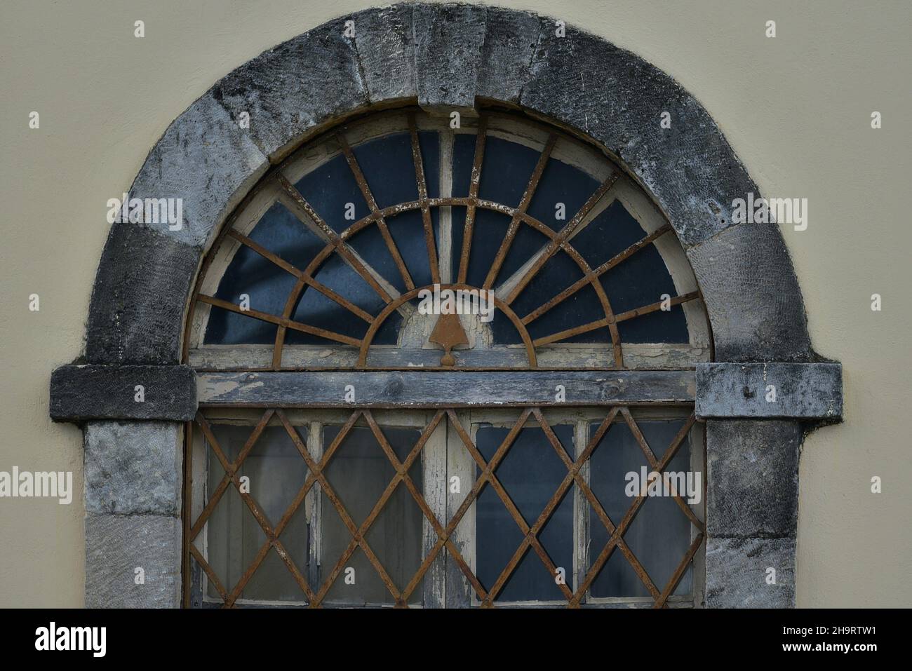 Antique arched window with marble trim and rusty wrought iron grilles ...