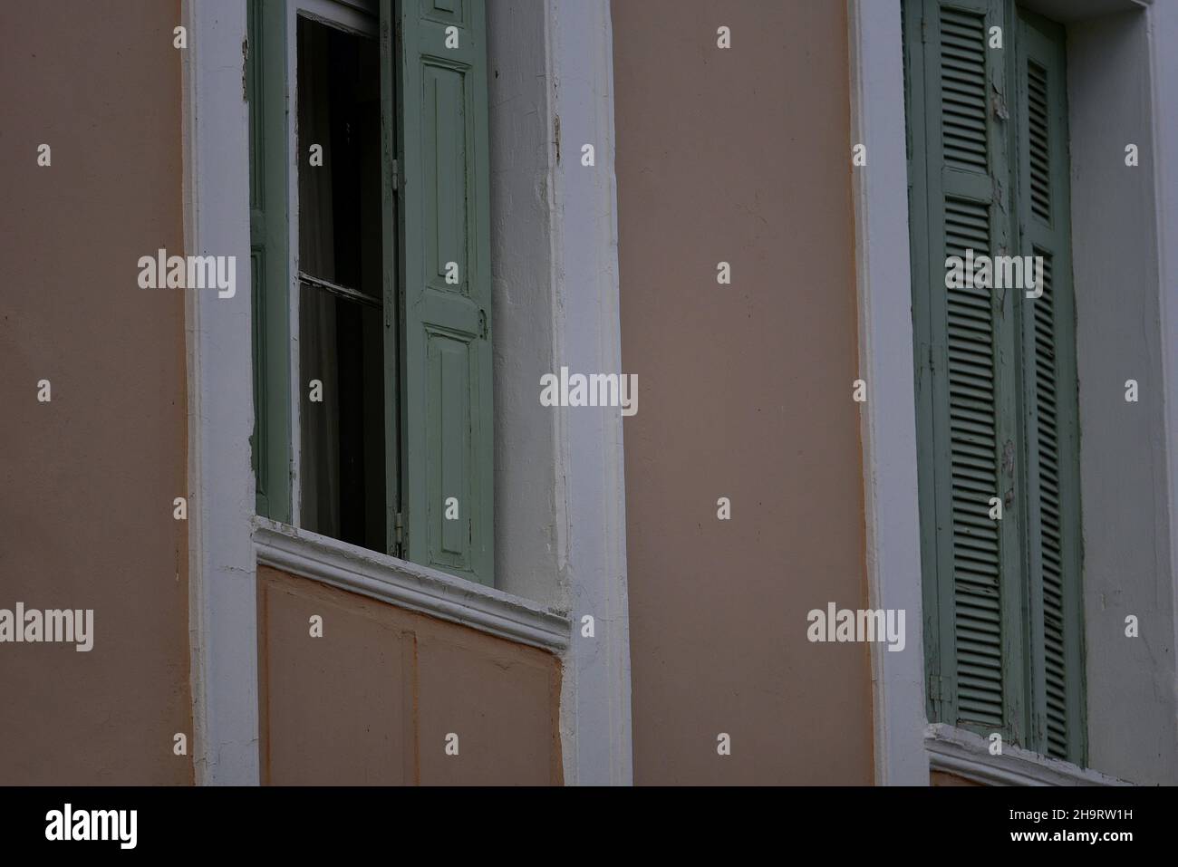 Old Neoclassical house windows with olive green wooden shutters and ...