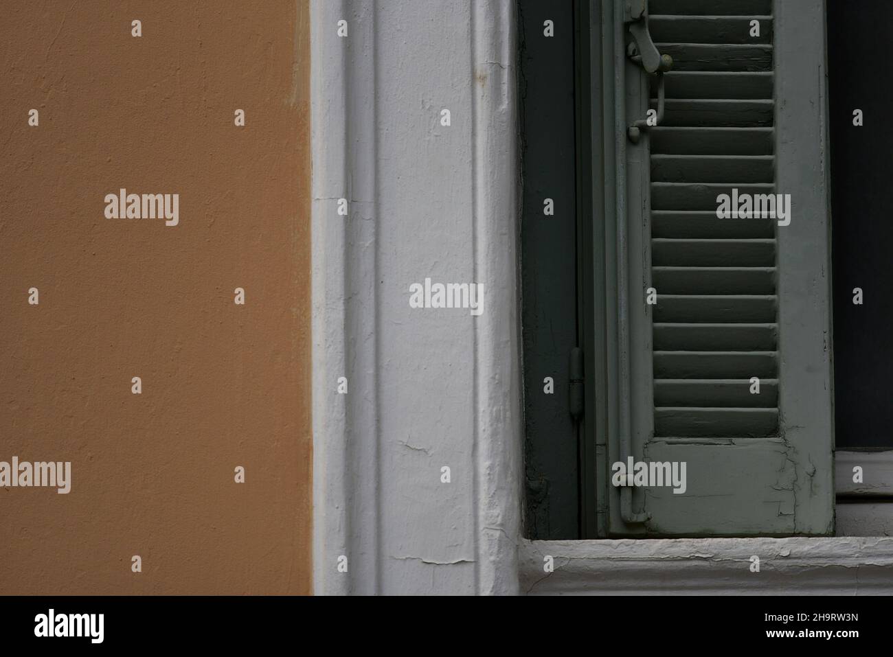 Old Neoclassical house window with grey wooden shutters and white trim ...