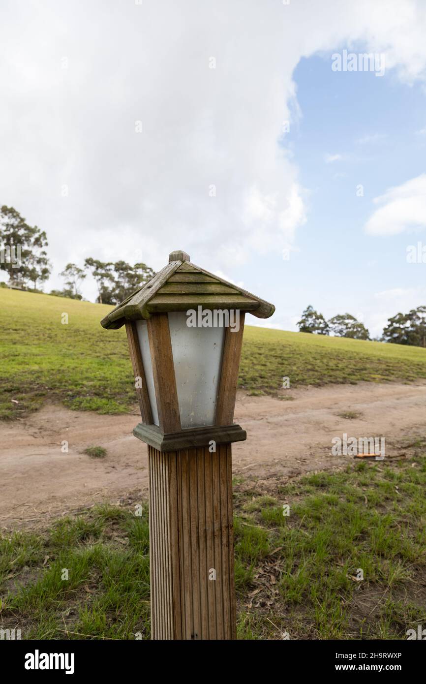 lamp with wooden house design next to a dirt road in the background ...