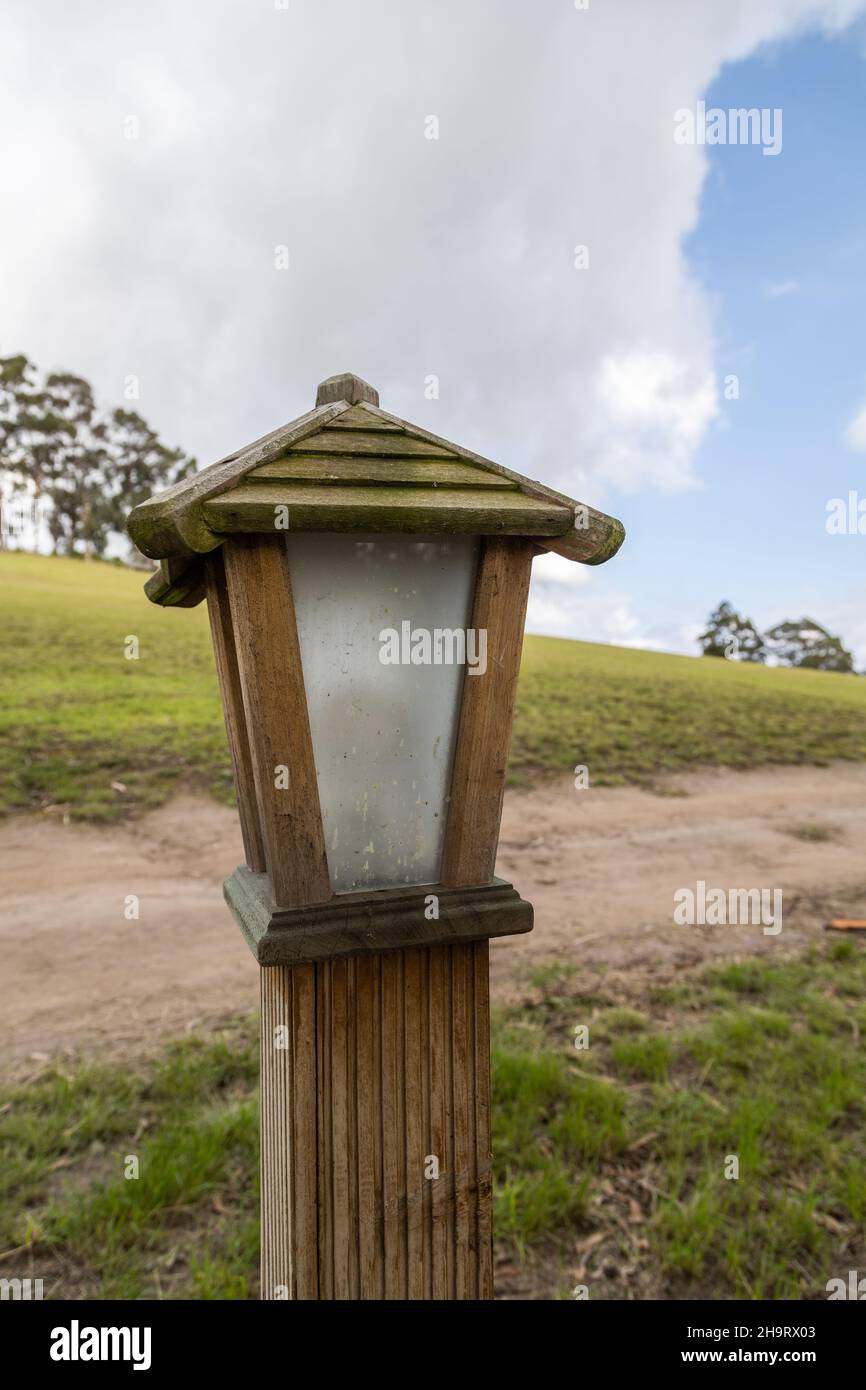 lamp details with wooden house design next to a dirt road in the ...