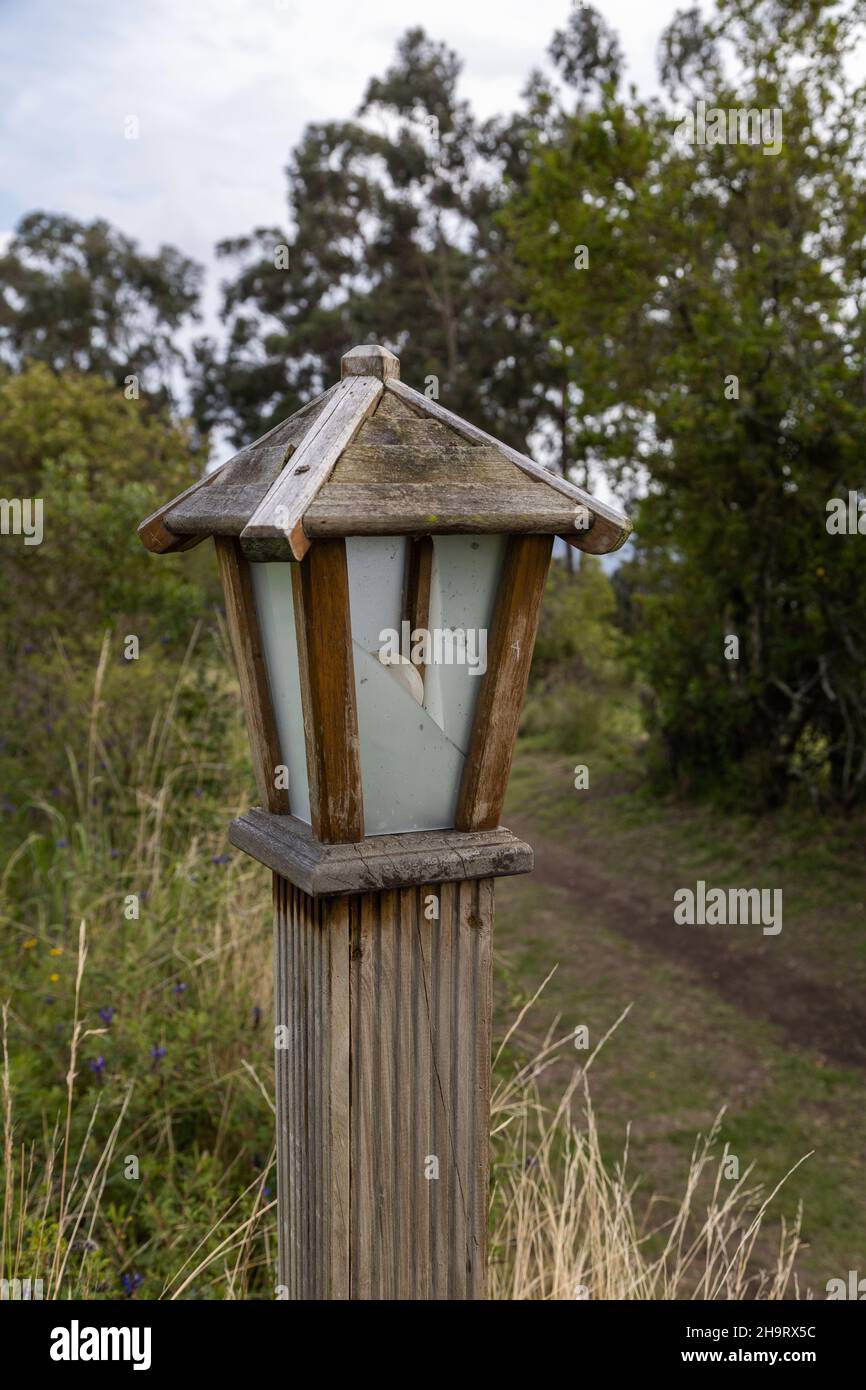 beautiful lamp with wooden house design next to a dirt road in a forest ...