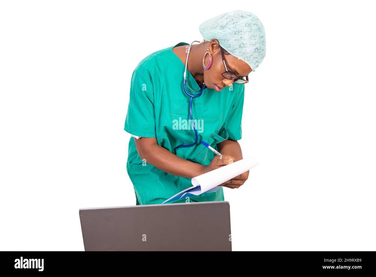 beautiful young female doctor taking notes on paper-press with laptop ...