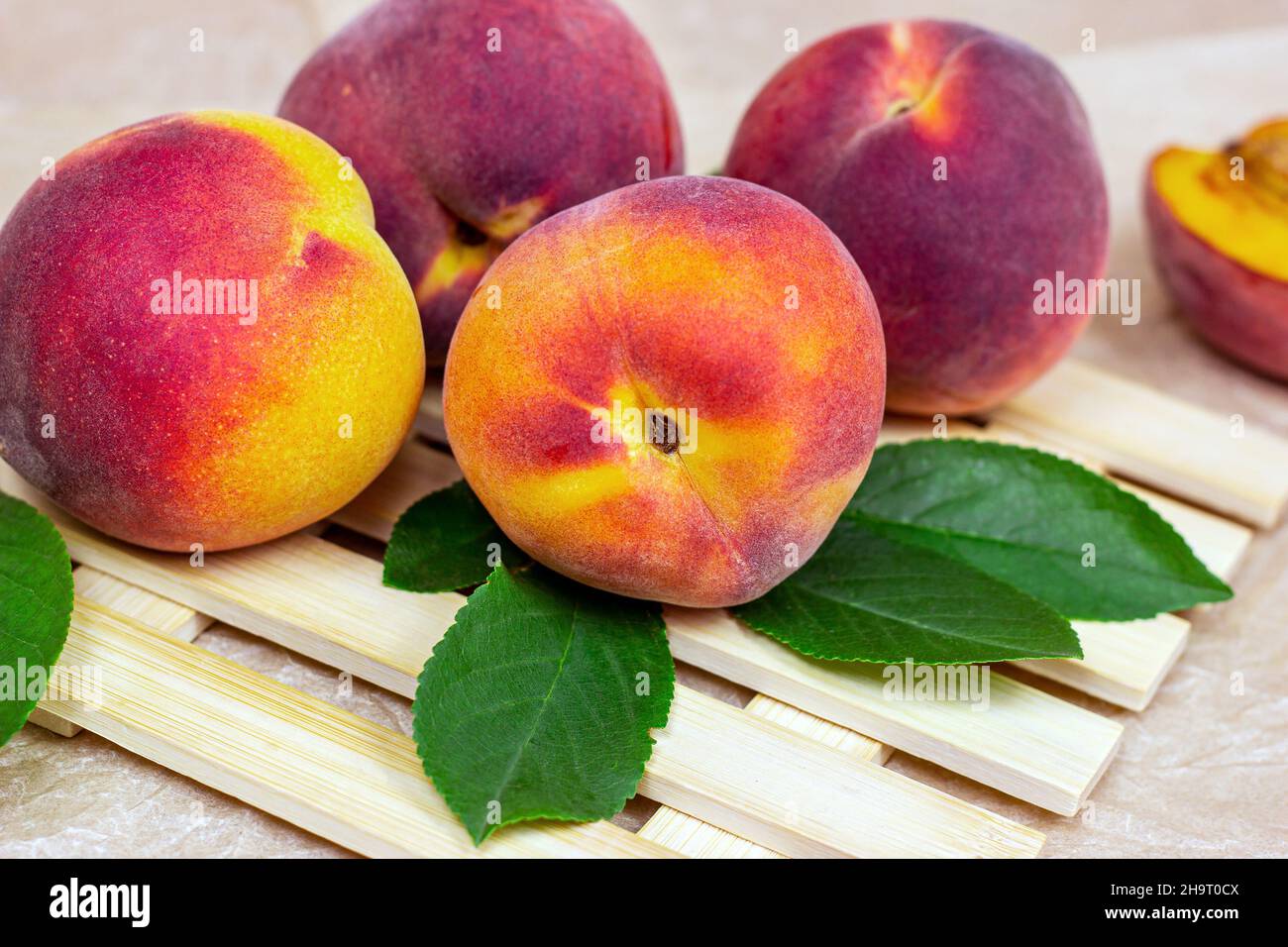 Fresh juicy red, yellow and orange peaches on light wooden table ...