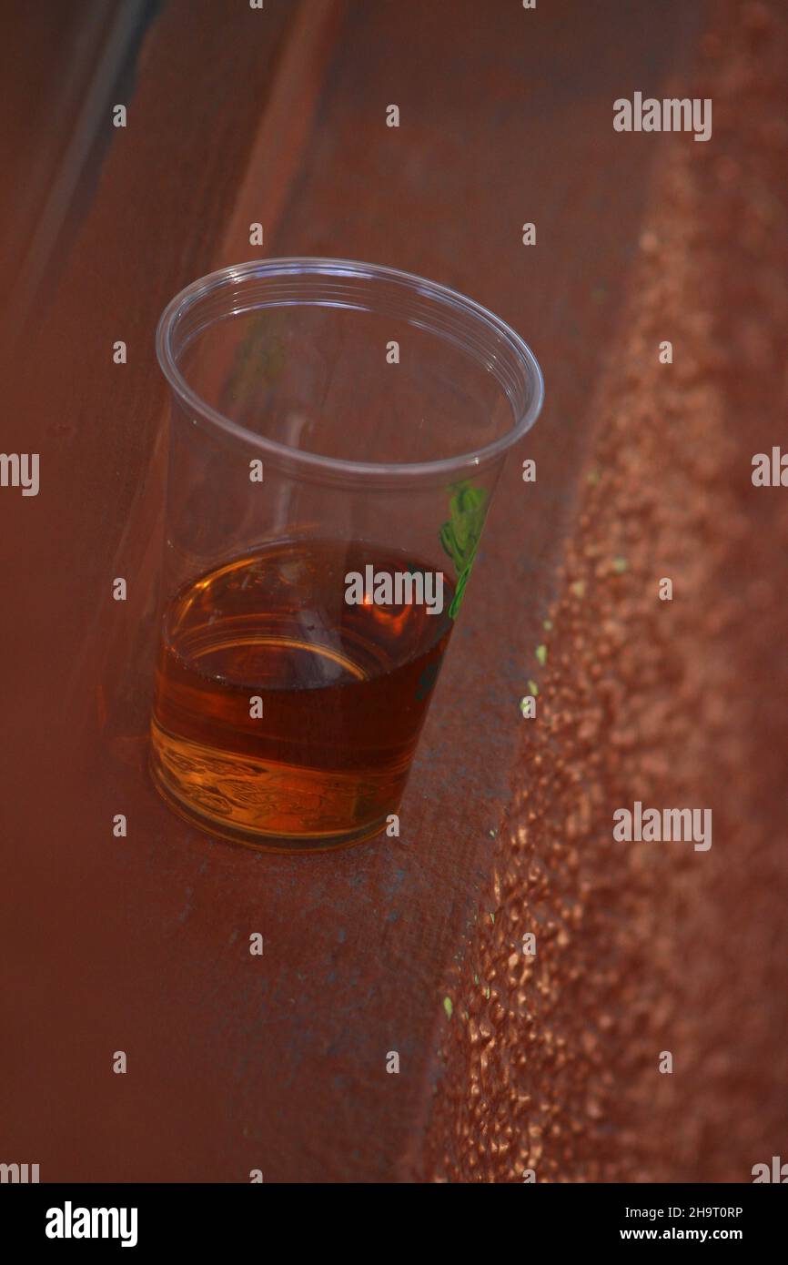 Vertical closeup of a half-empty plastic cup with beer Stock Photo - Alamy