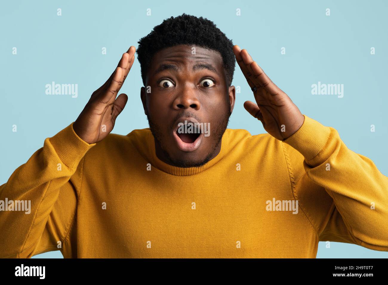 Shocked black man looking at camera, gesturing on blue Stock Photo - Alamy