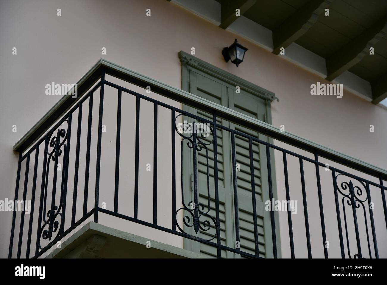 Old Neoclassical house facade with olive green wooden shutters and a ...