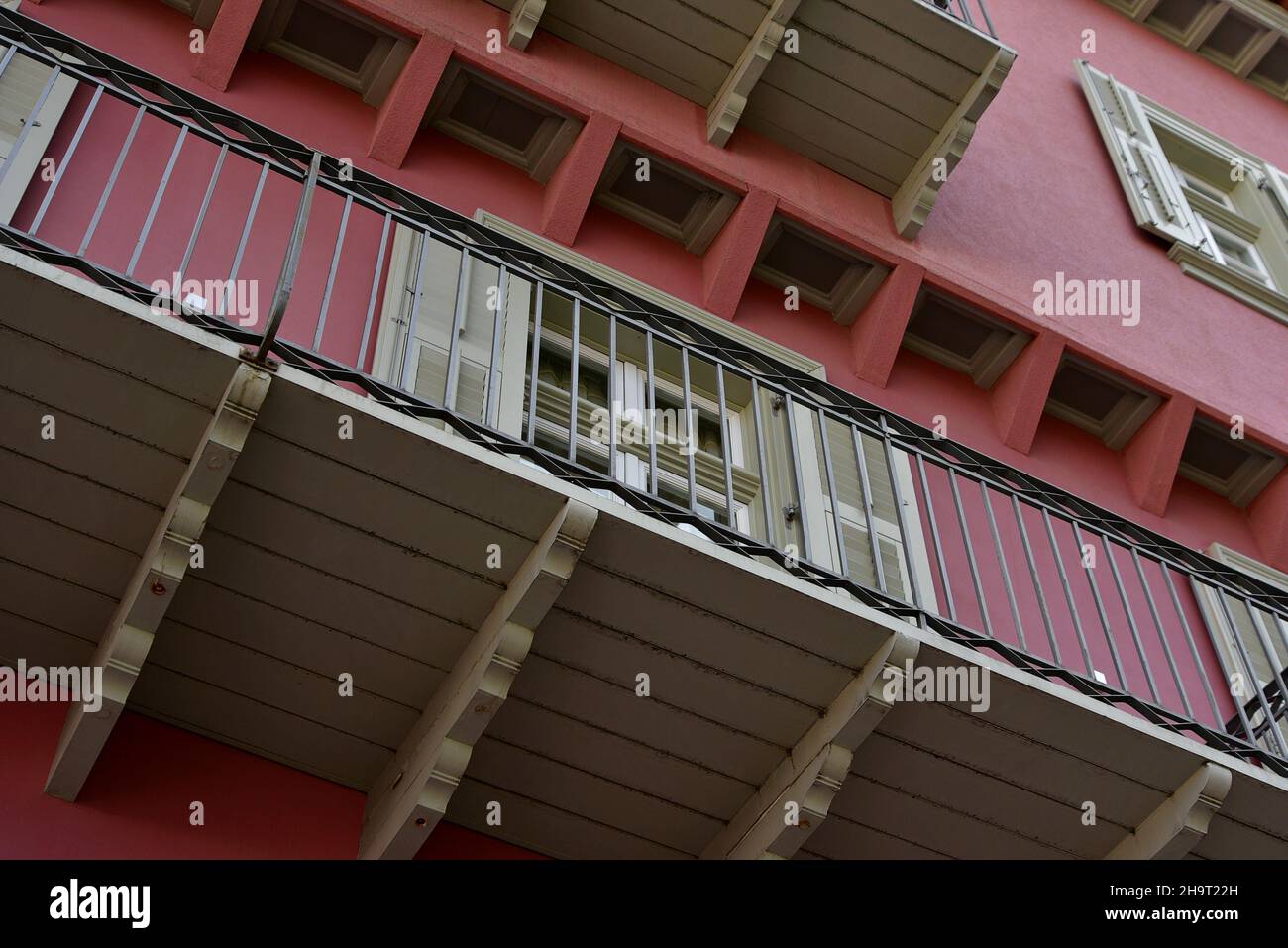 Old Neoclassical house facade with wooden window shutters and a balcony ...