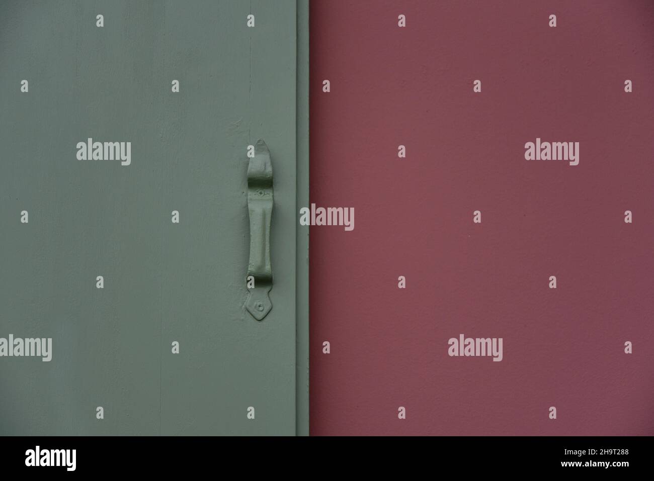 Olive green wooden window shutters against a magenta stucco wall in ...