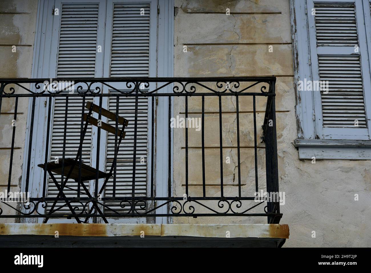 Old Neoclassical house facade with an aged stone wall, light blue ...