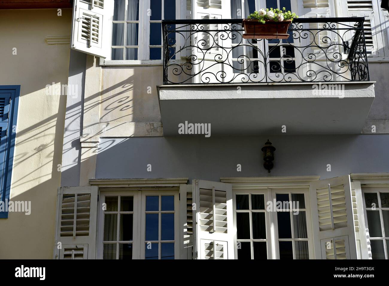 Neoclassical house facade with wooden window shutters and a balcony ...