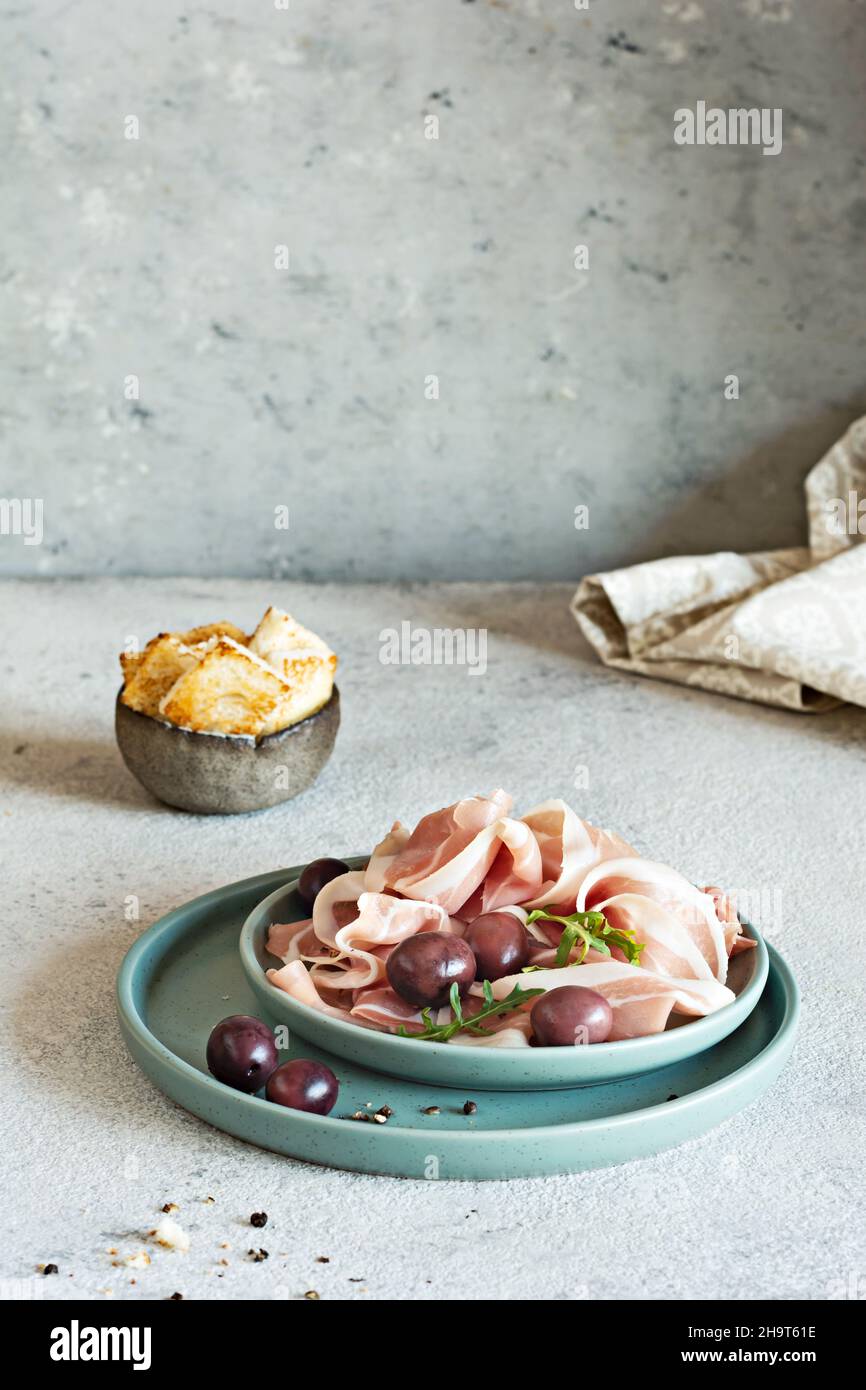 Slices of thinly sliced ham (prosciutto, Parma ham) with a bowl of ...