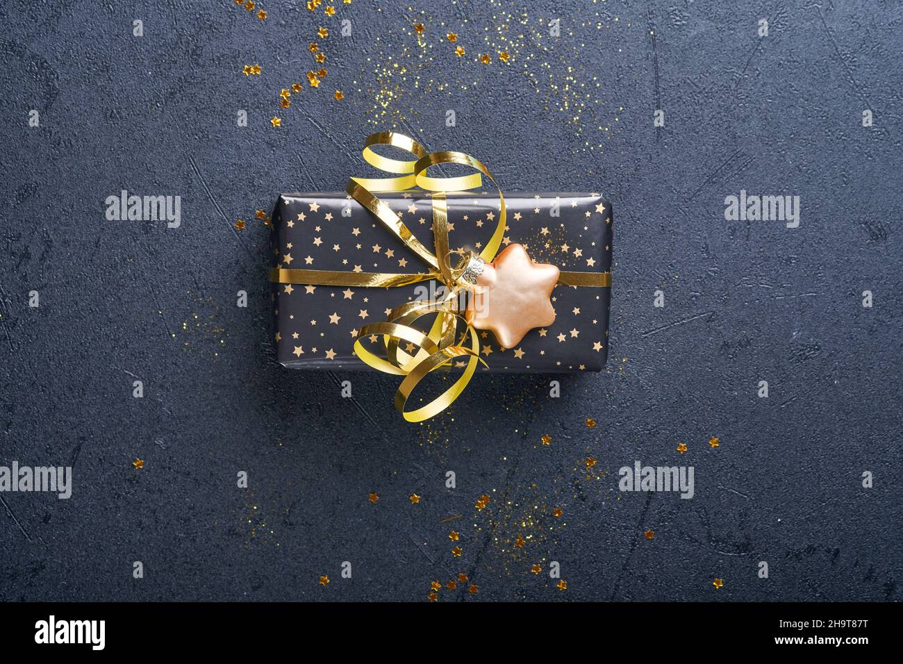 Holiday gift box or present with ribbon, golden confetti and gold ...