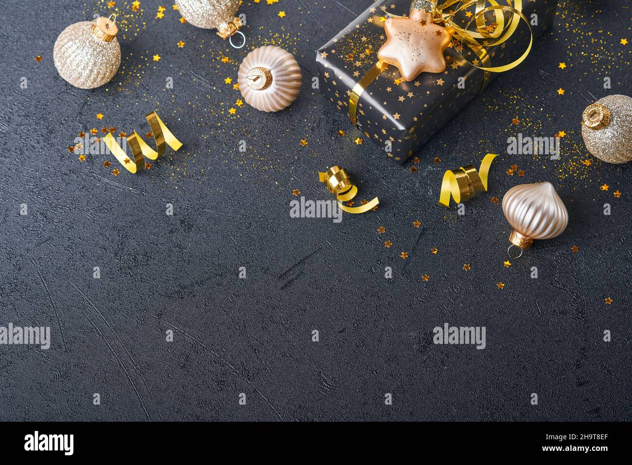 Holiday gift box or present with ribbon, golden confetti and gold ...