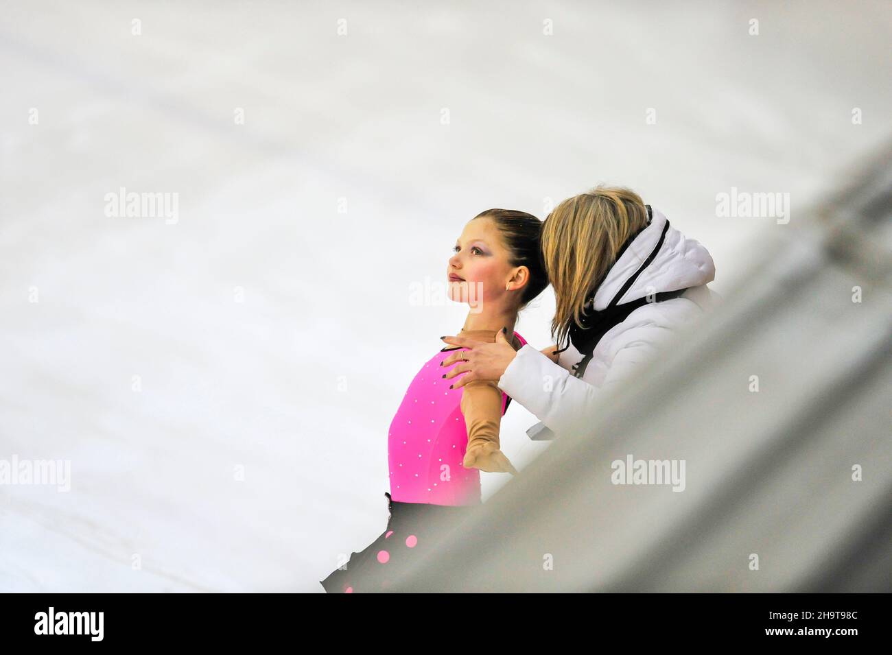 Little girl figure skater on indoor ice with her trainer Stock Photo ...