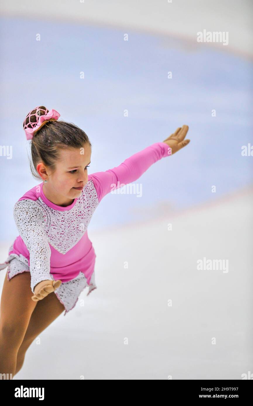 Little girl figure skater skating on ice indoor Stock Photo - Alamy