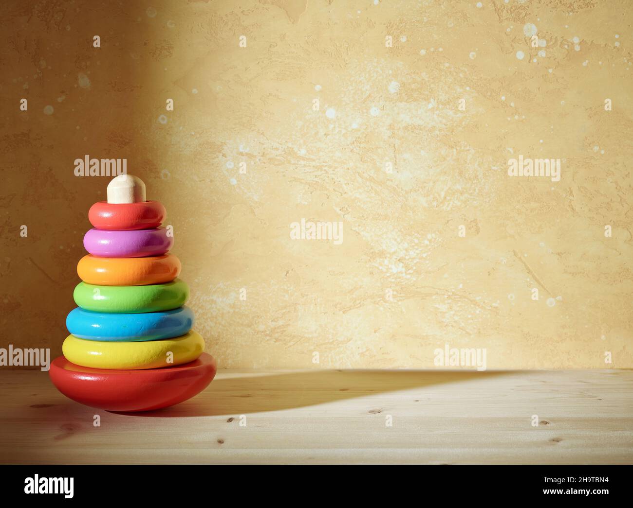 colorful wooden toy pyramid on shelf and yellow wall background Stock ...