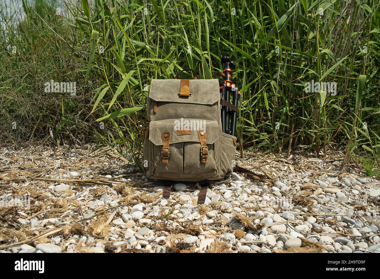 photography backpack with tripod on small stones on the beach, object ...