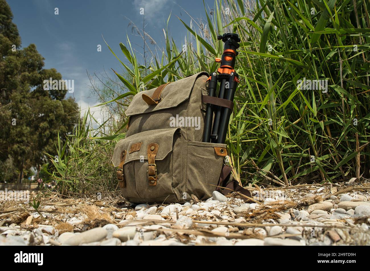 photography backpack with tripod on small stones on the beach, object ...