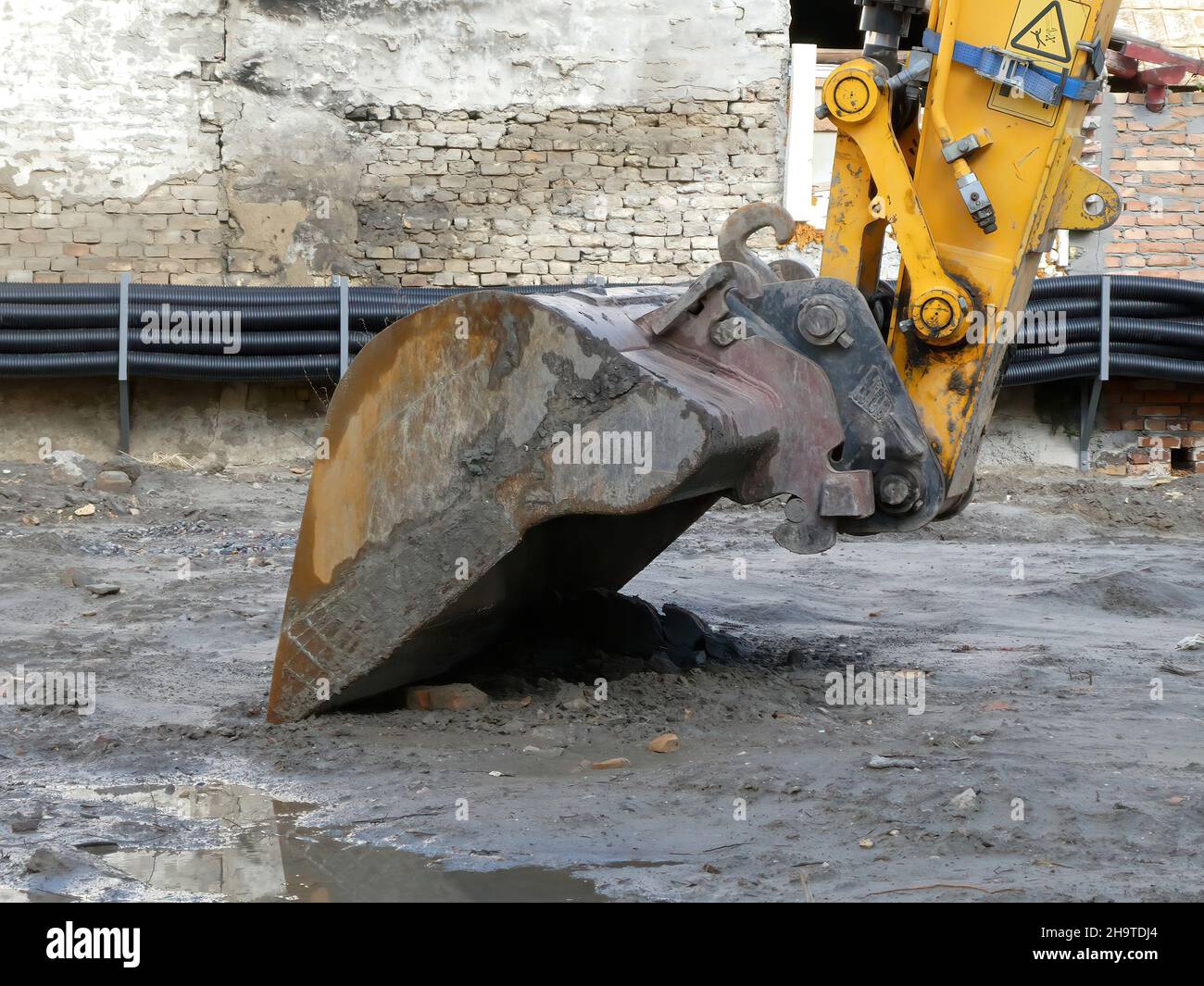 A bucket of yellow excavators on the field where the building wi Stock ...