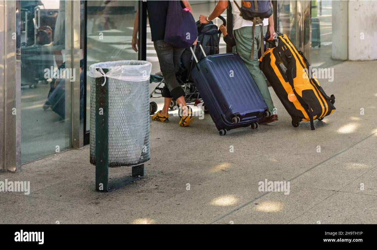 Couple pulling their trolley baggage behind them to airport, view from ...