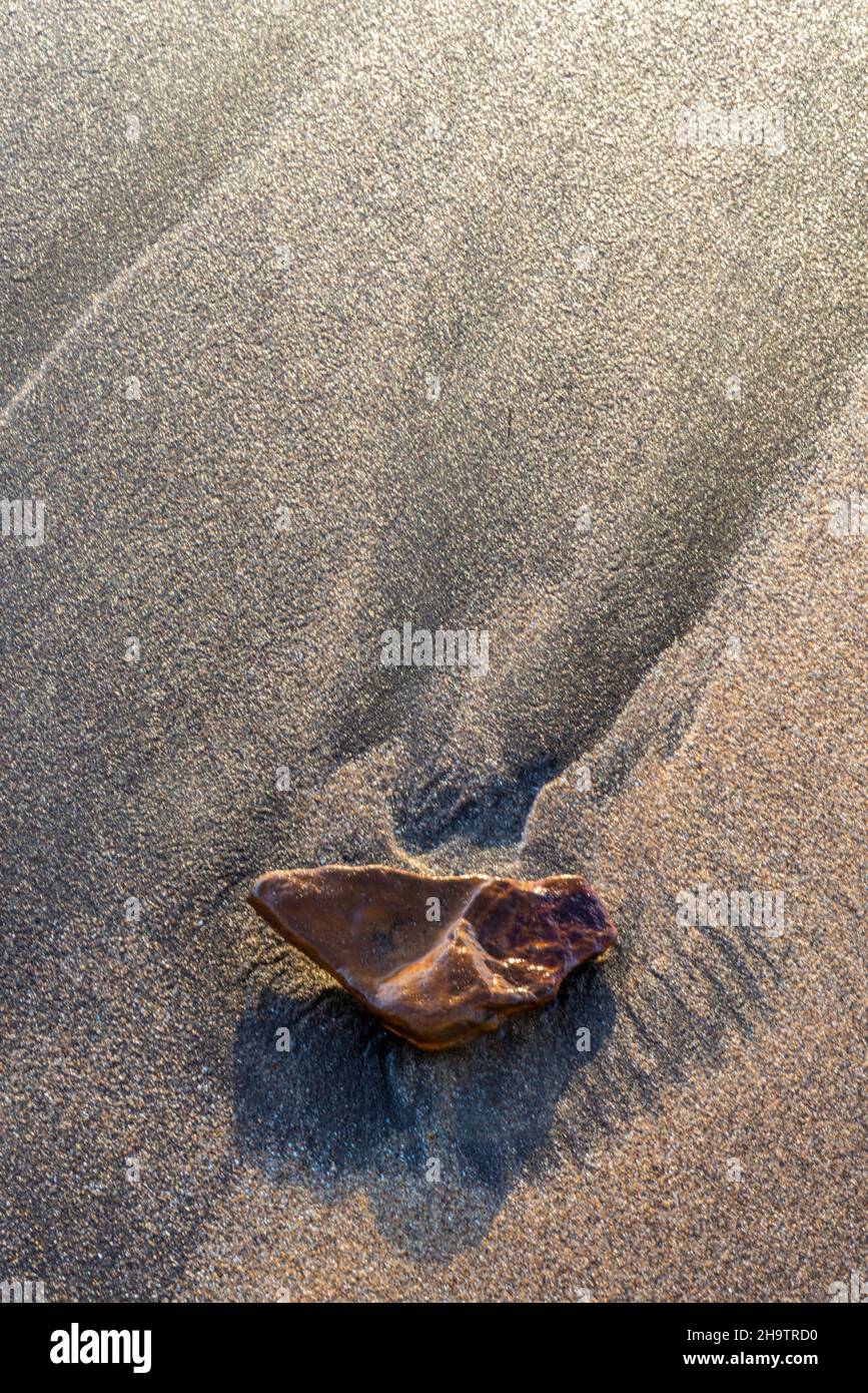 single solitary stone or pebble on beach, sandy beach with single ...