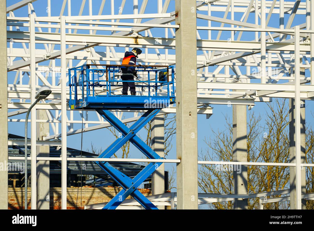 worker in uniform and safety protective equipment on self propelled ...