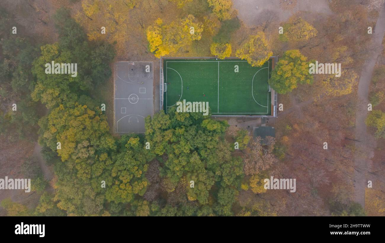 Football field with green grass and basketball court in city park in ...