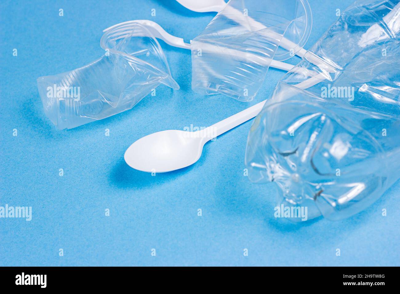 Crushed plastic spoons, forks, bottles and cups as a disposable waste ...