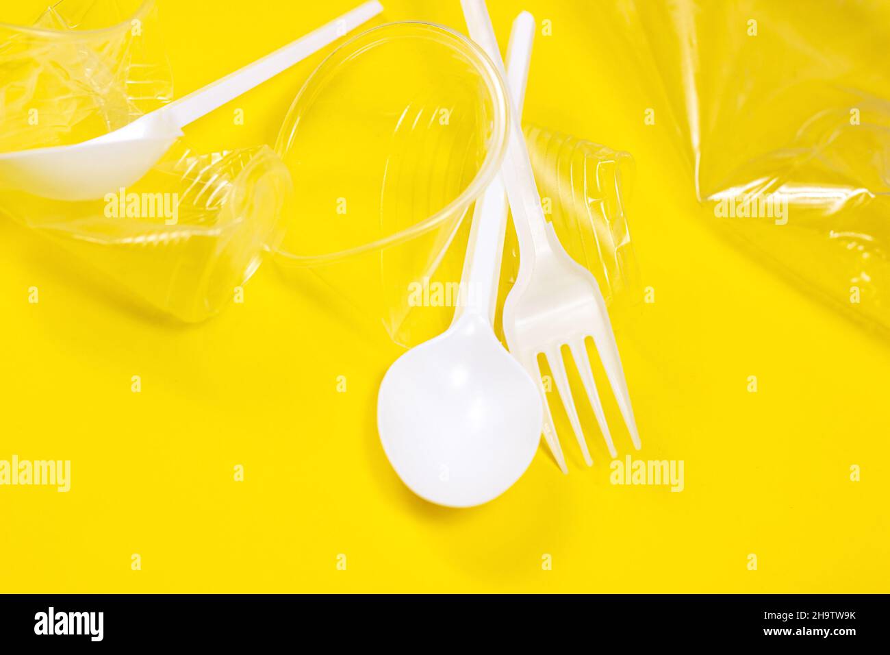 Crushed plastic spoons, forks, bottles and cups as a disposable waste ...