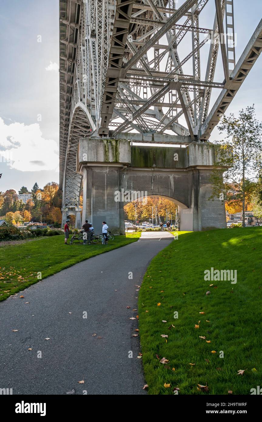 People and bicycles along the Burke Gilman Trail near the underside of ...