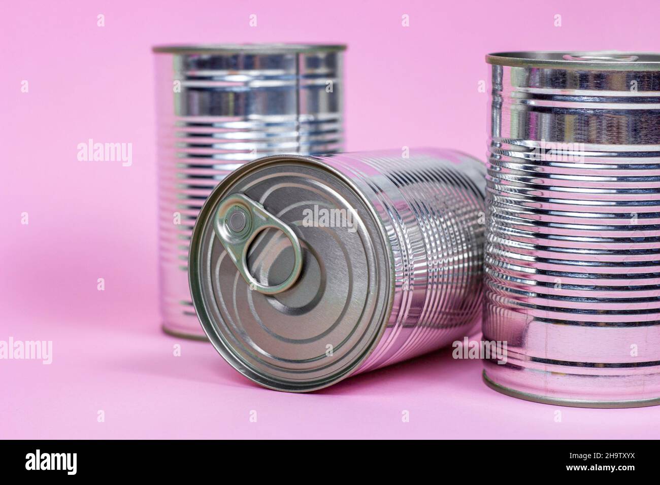 Tinned food and metal cans storage on light pink background Stock Photo ...