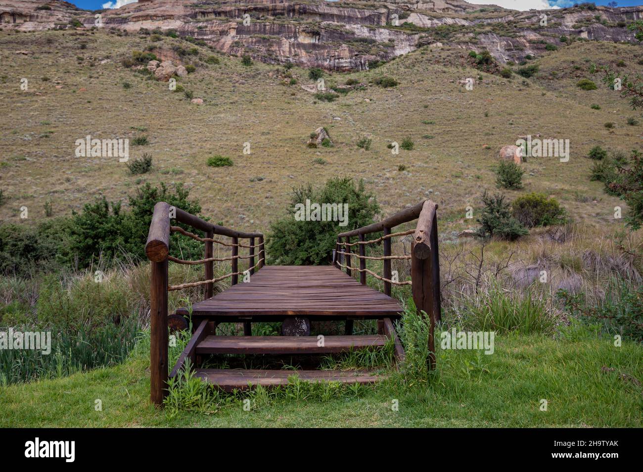 Wooden bridge leading into the distance with a mountain behind the ...