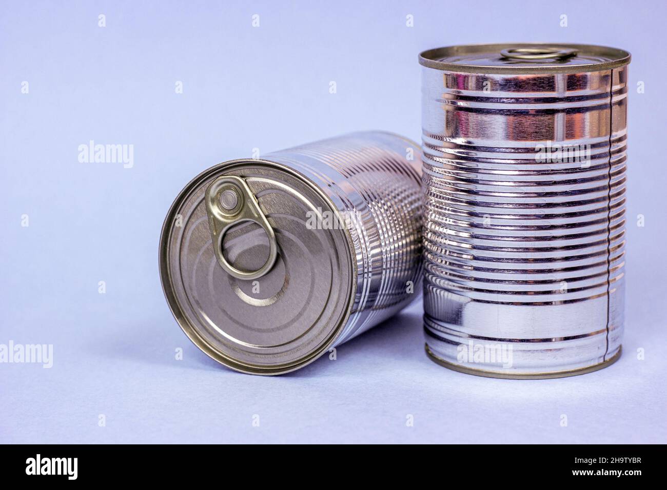 Tinned food and metal cans storage on light blue background Stock Photo ...