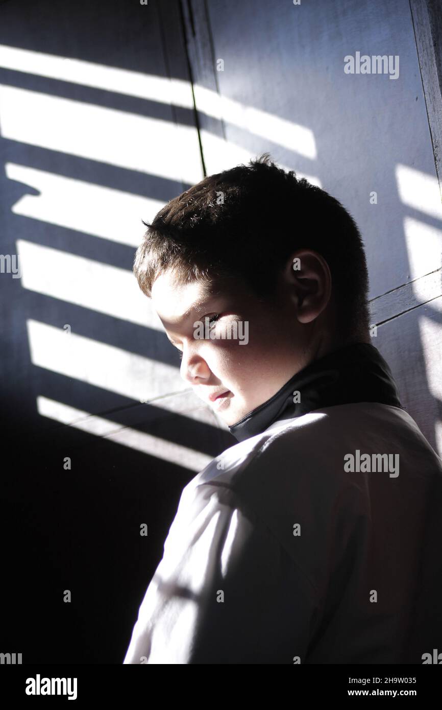 Portrait of a handsome young boy from Cuba in a window shade in ...