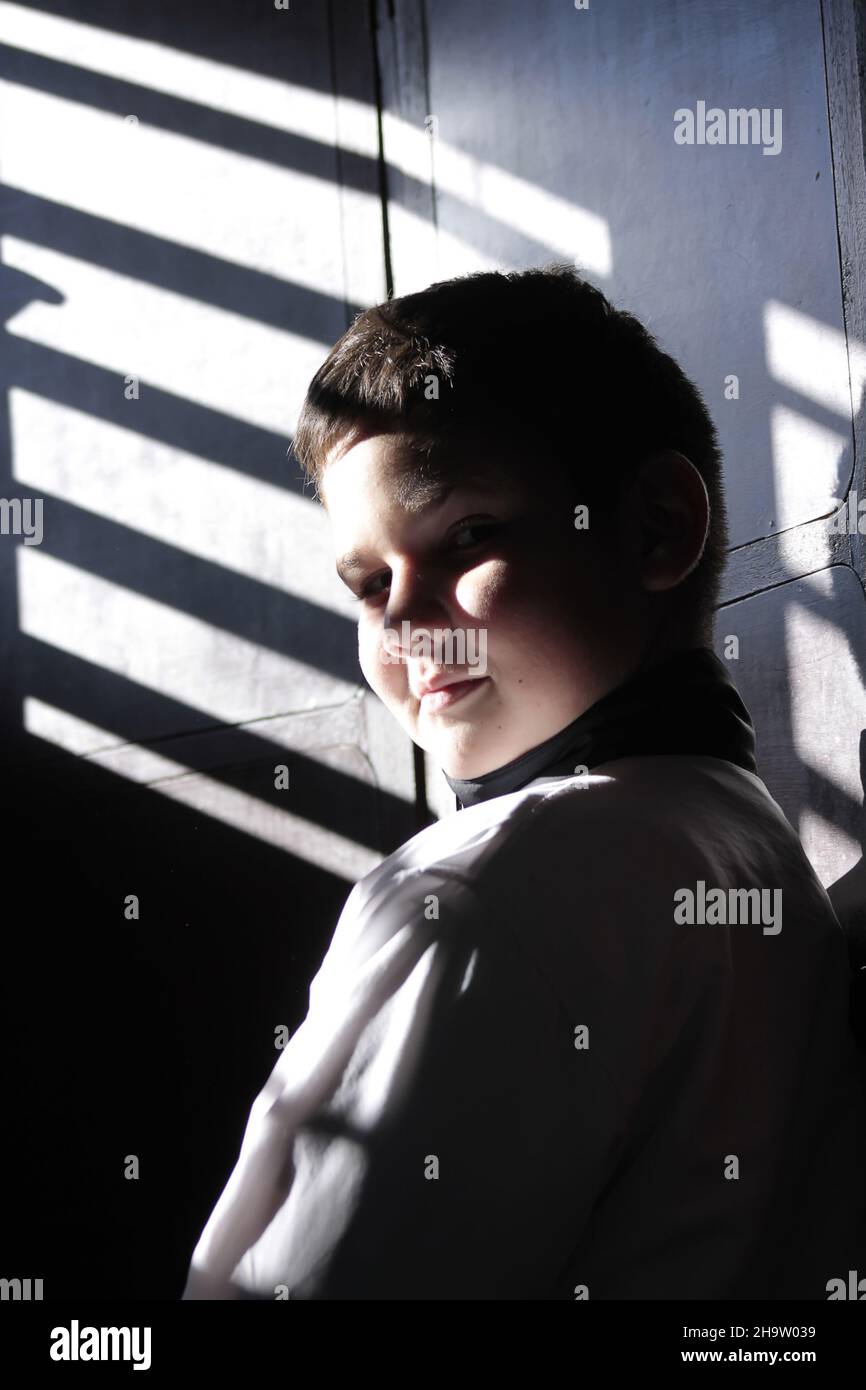 Portrait of a handsome young boy from Cuba in a window shade in ...