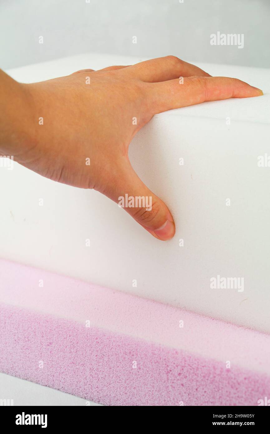 the hand presses on the surface of the rubber foam. Checking hardness ...